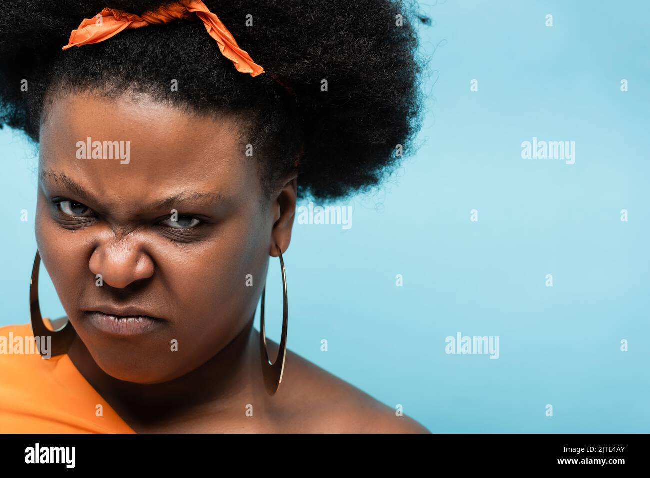 Portrait Of Angry African American Body Positive Woman In Hoop Earrings