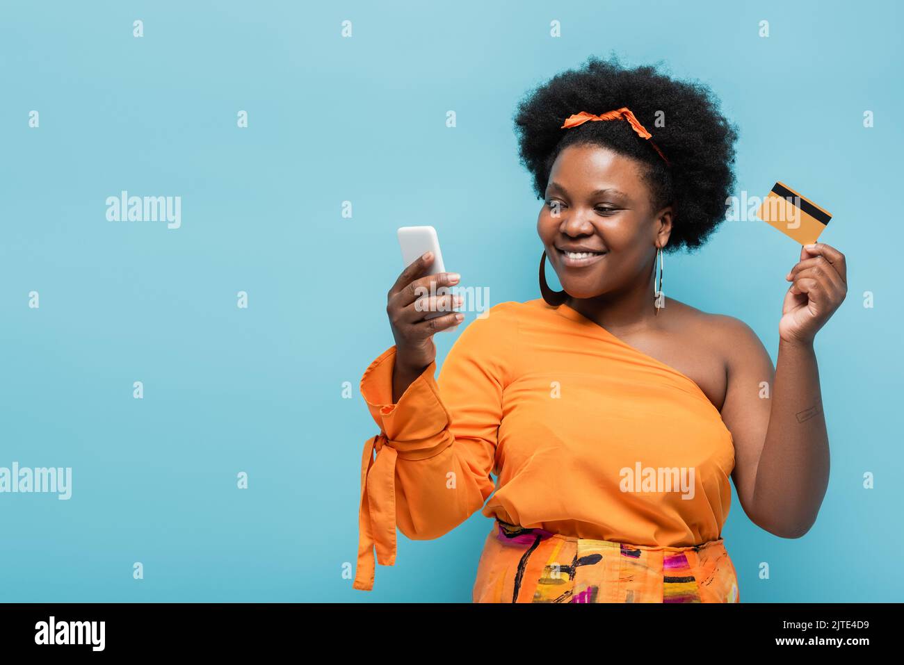 Happy African American Body Positive Woman In Hoop Earrings Holding