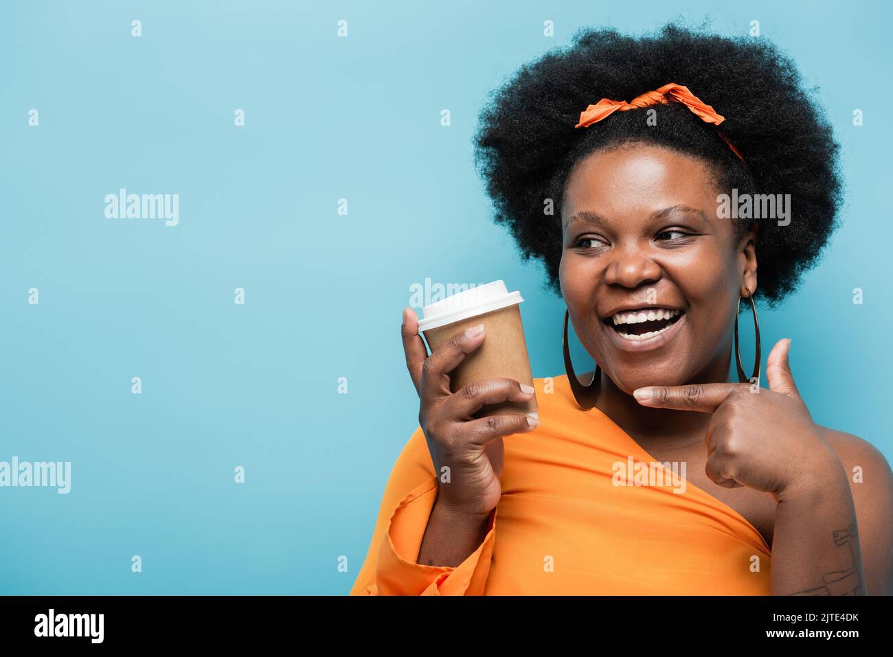Happy African American Body Positive Woman In Hoop Earrings Pointing At