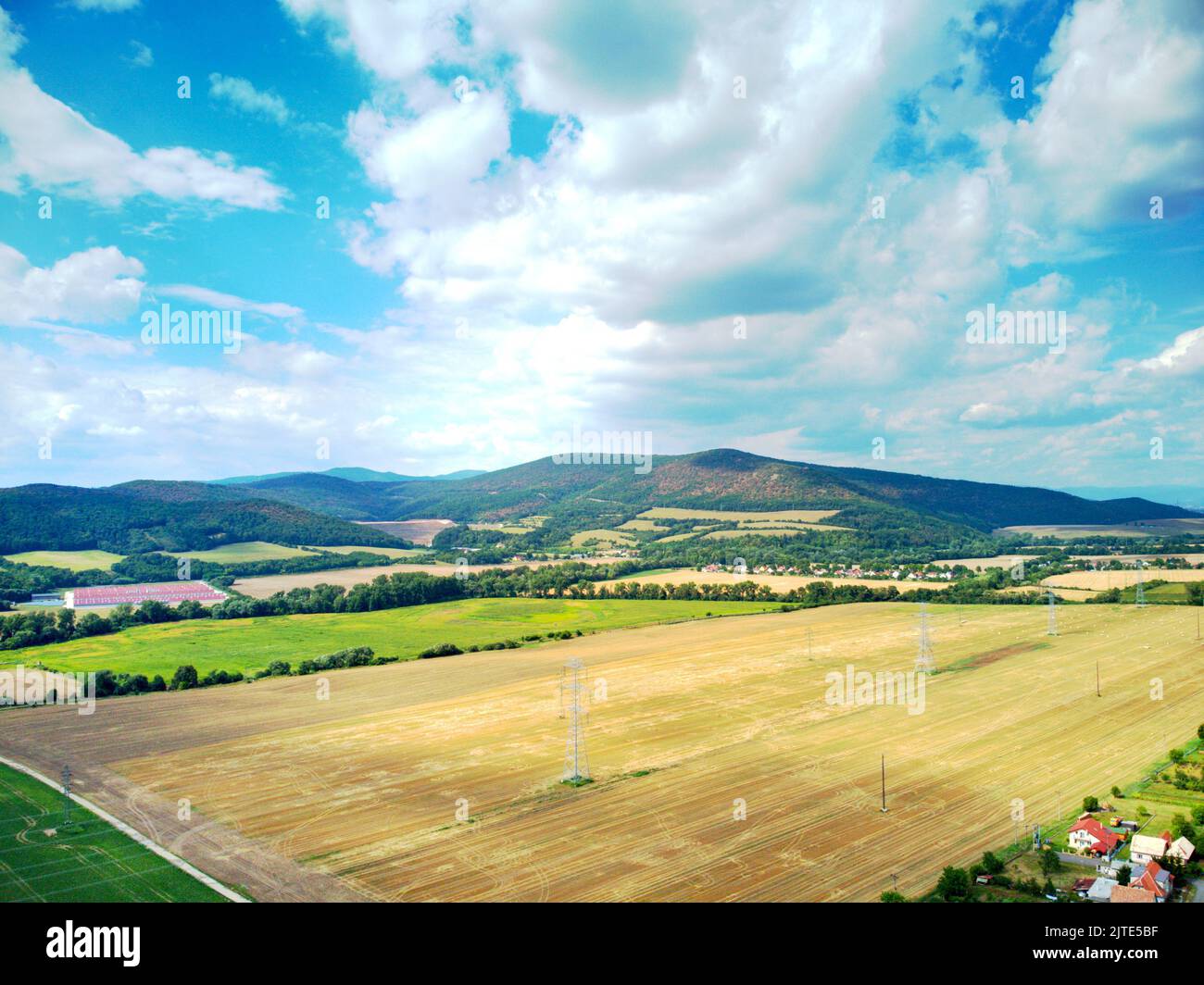 An aerial view of houses and large fields in a rural area under blue ...