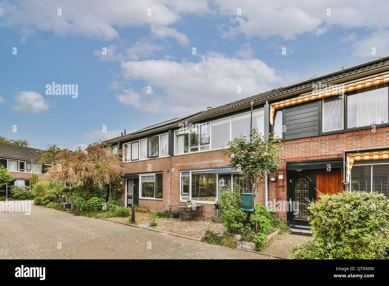 The front view of a brick building with signs,pavement and wooden doors ...