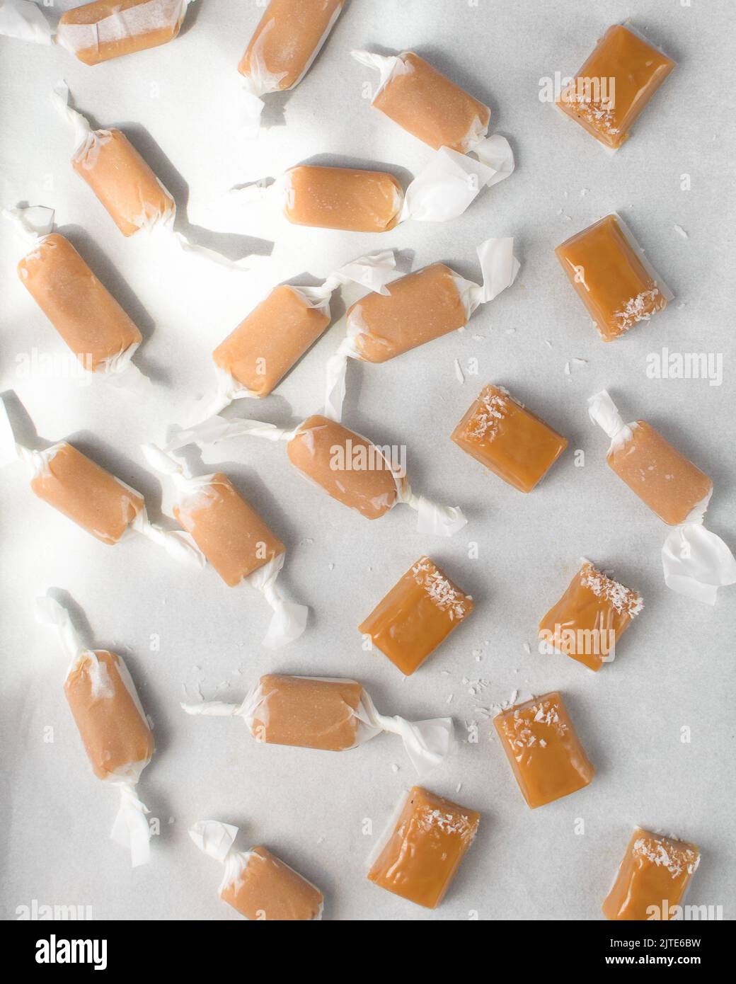 chewy caramels wrapped and unwrapped. Caramel candies in a small bowl ...