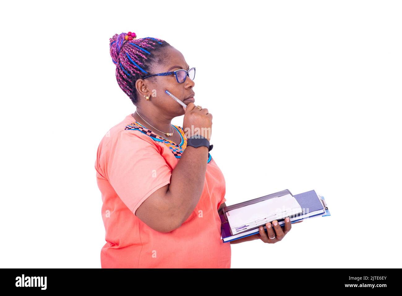 mature business woman wearing glasses, standing sideways thinking what ...