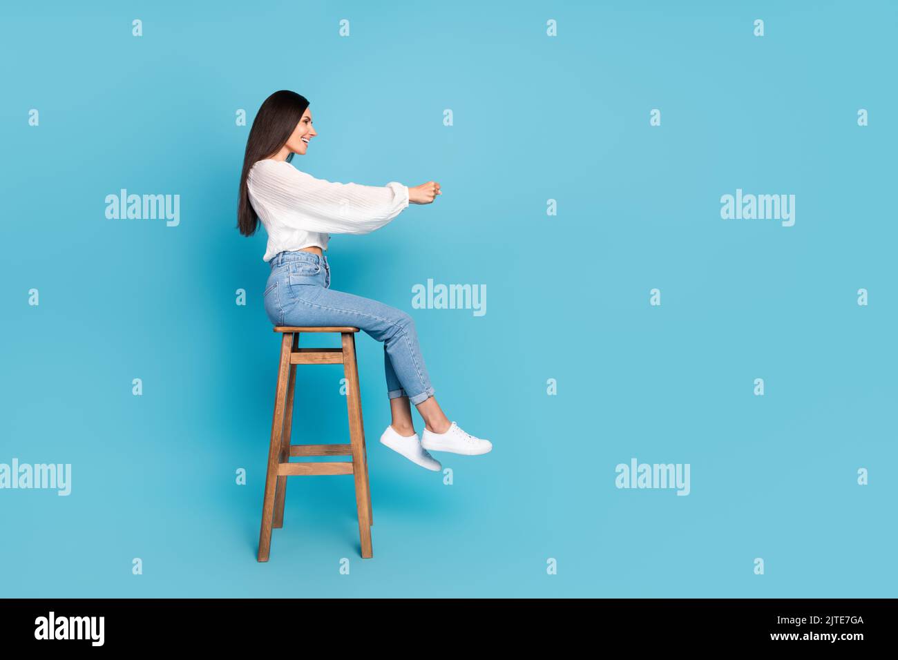 Full size profile photo of positive pretty girl sit stool arms hold ...