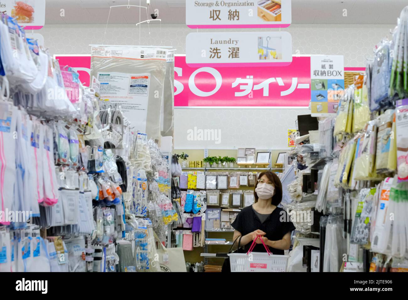 Tokyo, Japan. 30th Aug, 2022. A woman shopping at Daiso 100 Yen Store while wearing a face mask ...