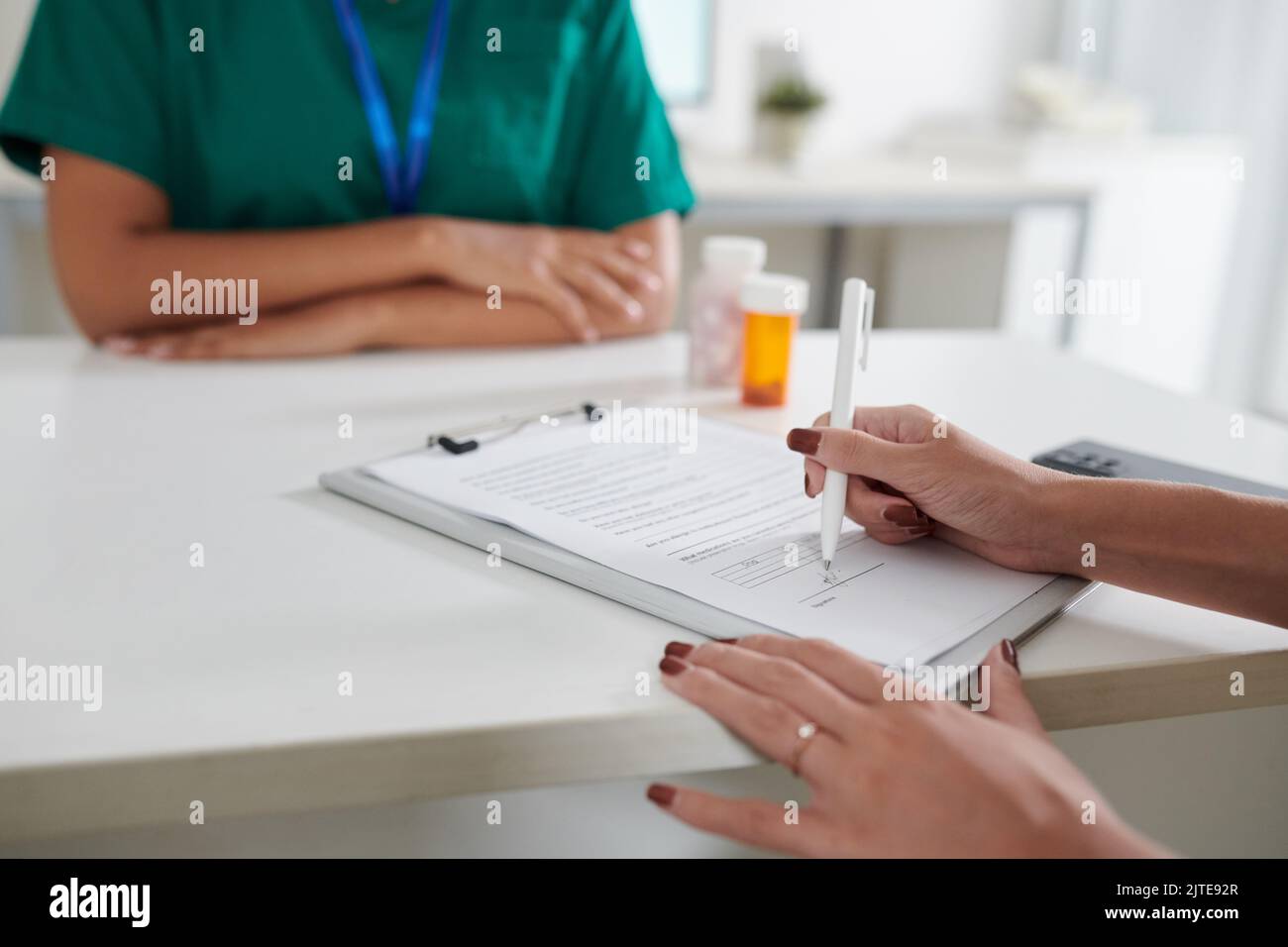 Hands of female patient filling medical documents before examination ...