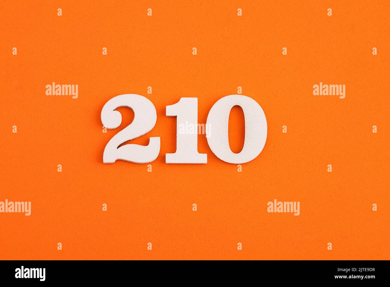 White wooden number 210 on eva rubber orange background Stock Photo - Alamy