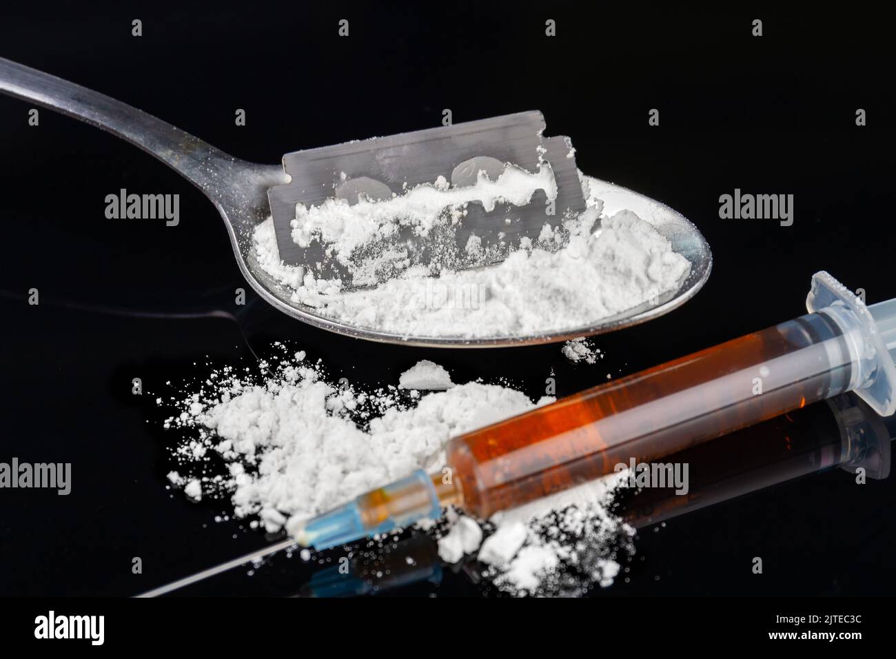 Close-up syringe and spoon with heroin. Drug addiction concept. White ...