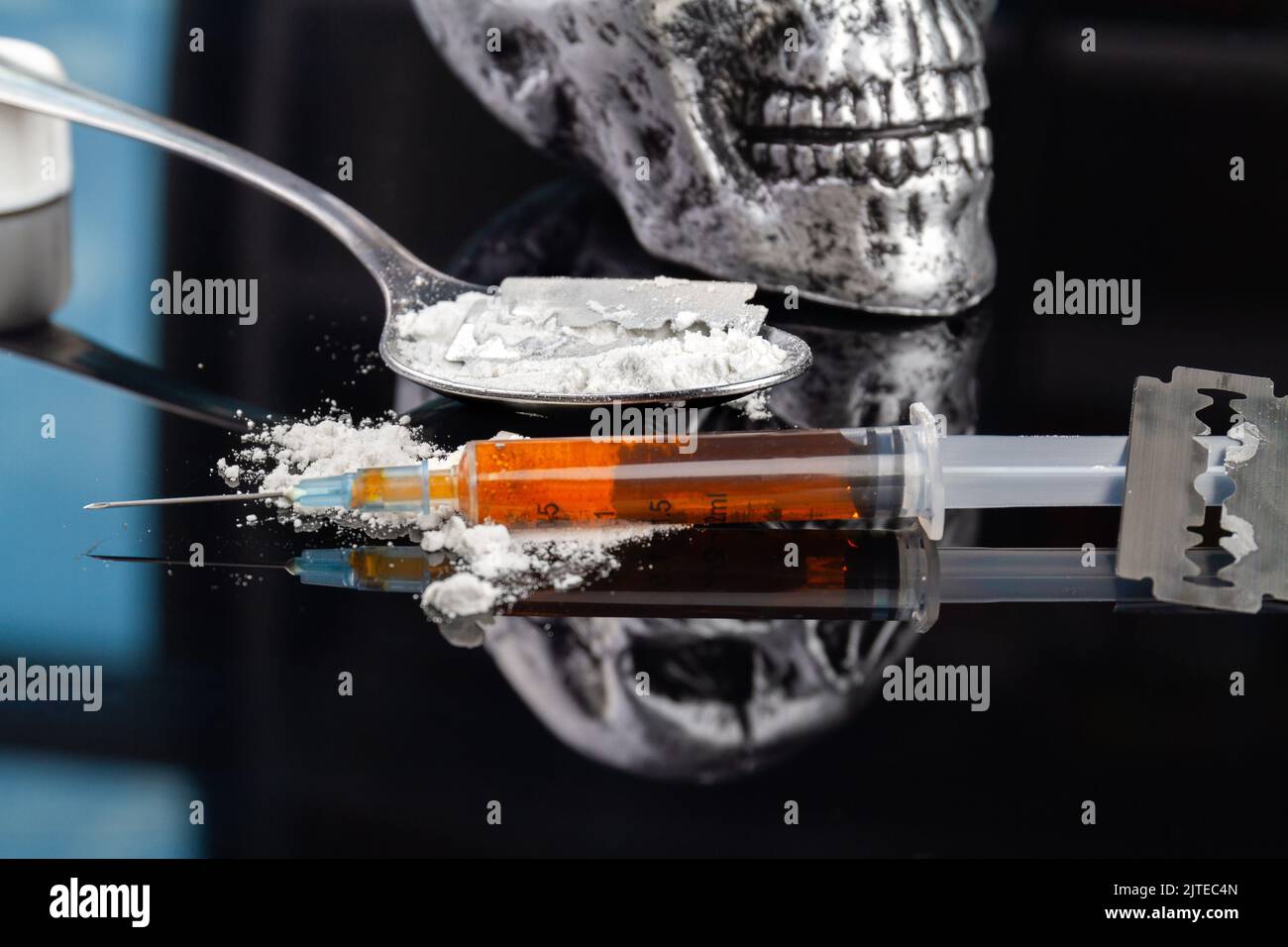 Close-up of syringe filled with drugs and spoon with heroin powder ...