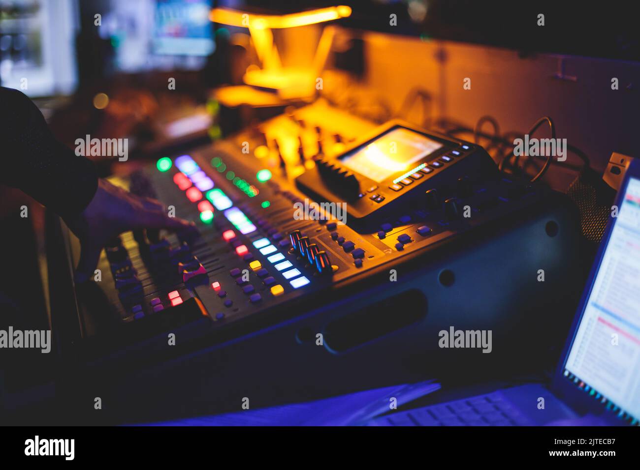 View of lighting technician operator working on mixing console ...