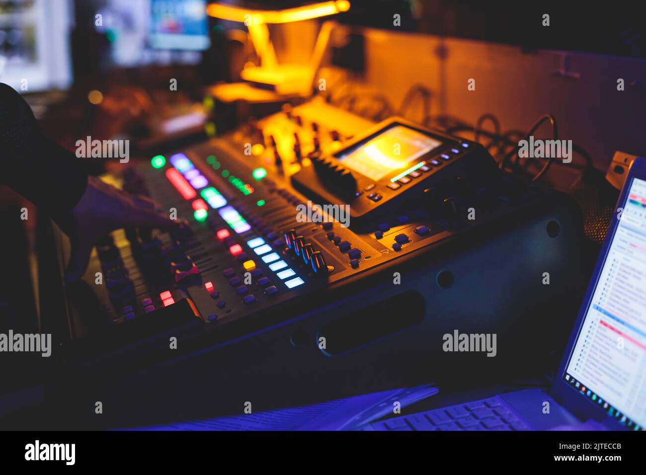 View of lighting technician operator working on mixing console ...