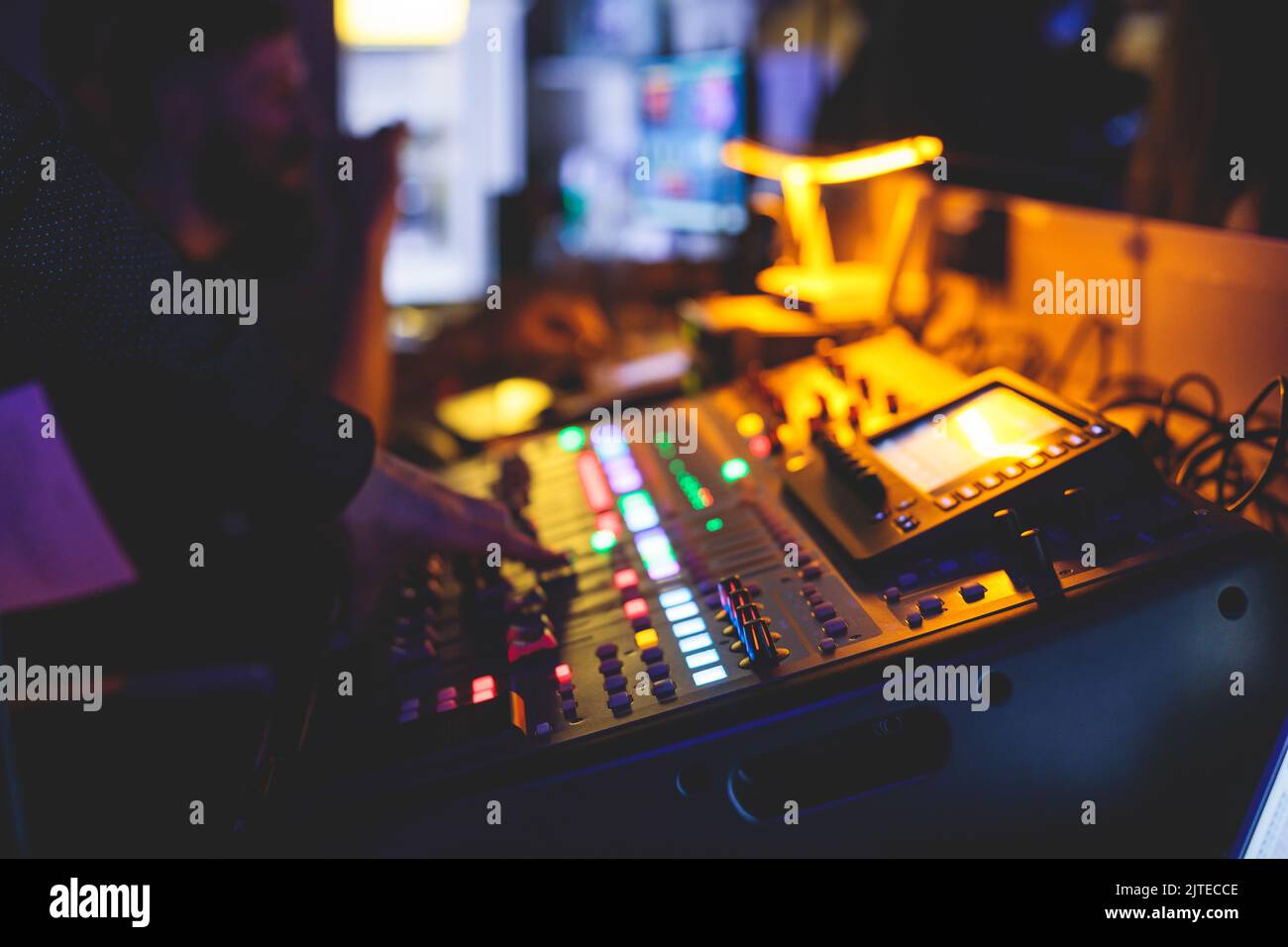 View of lighting technician operator working on mixing console ...