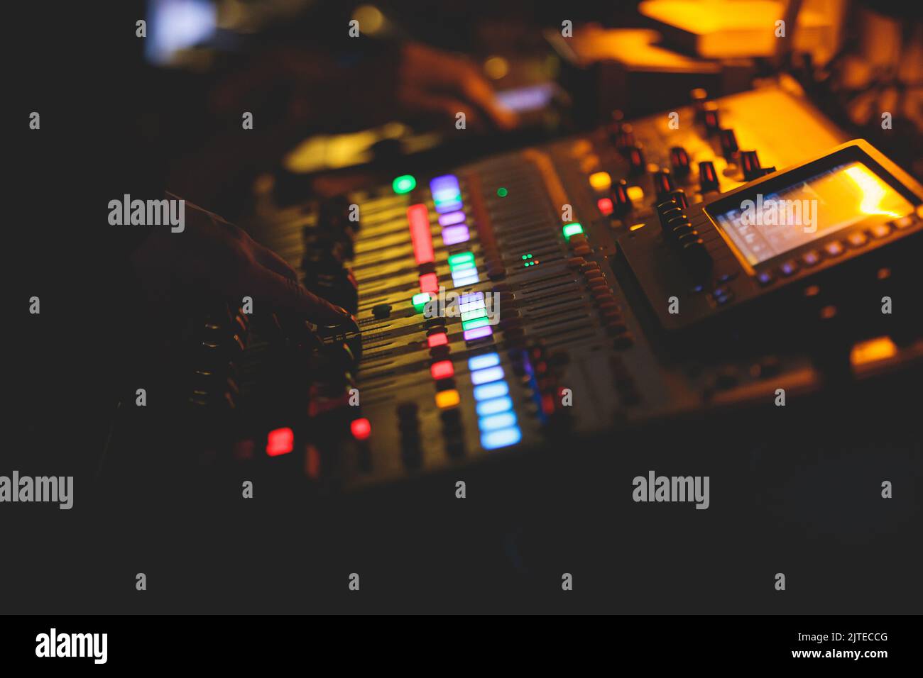 View of lighting technician operator working on mixing console ...