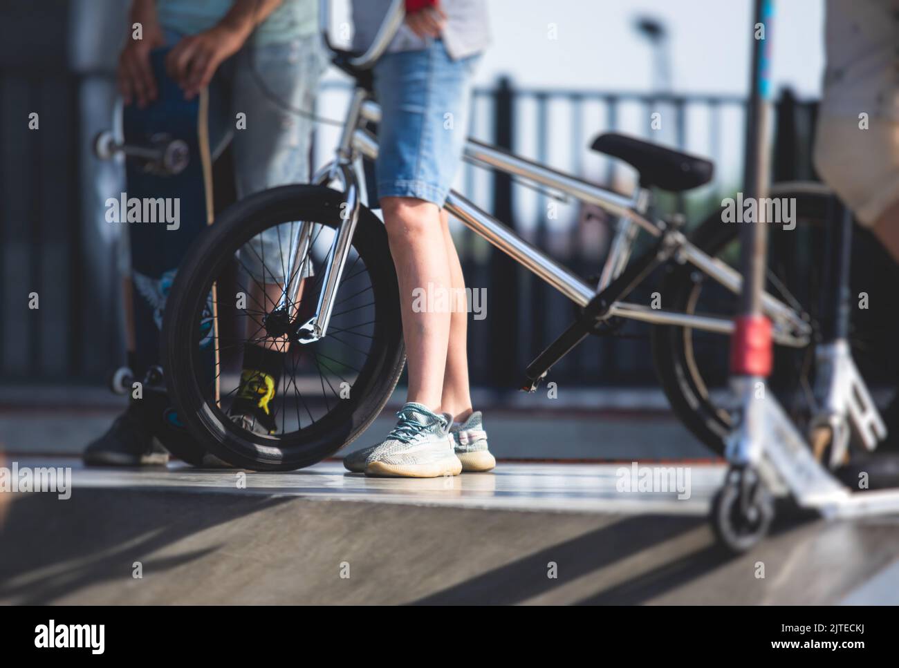 Skate park view with kids on a kick scooter doing tricks and stunts ...