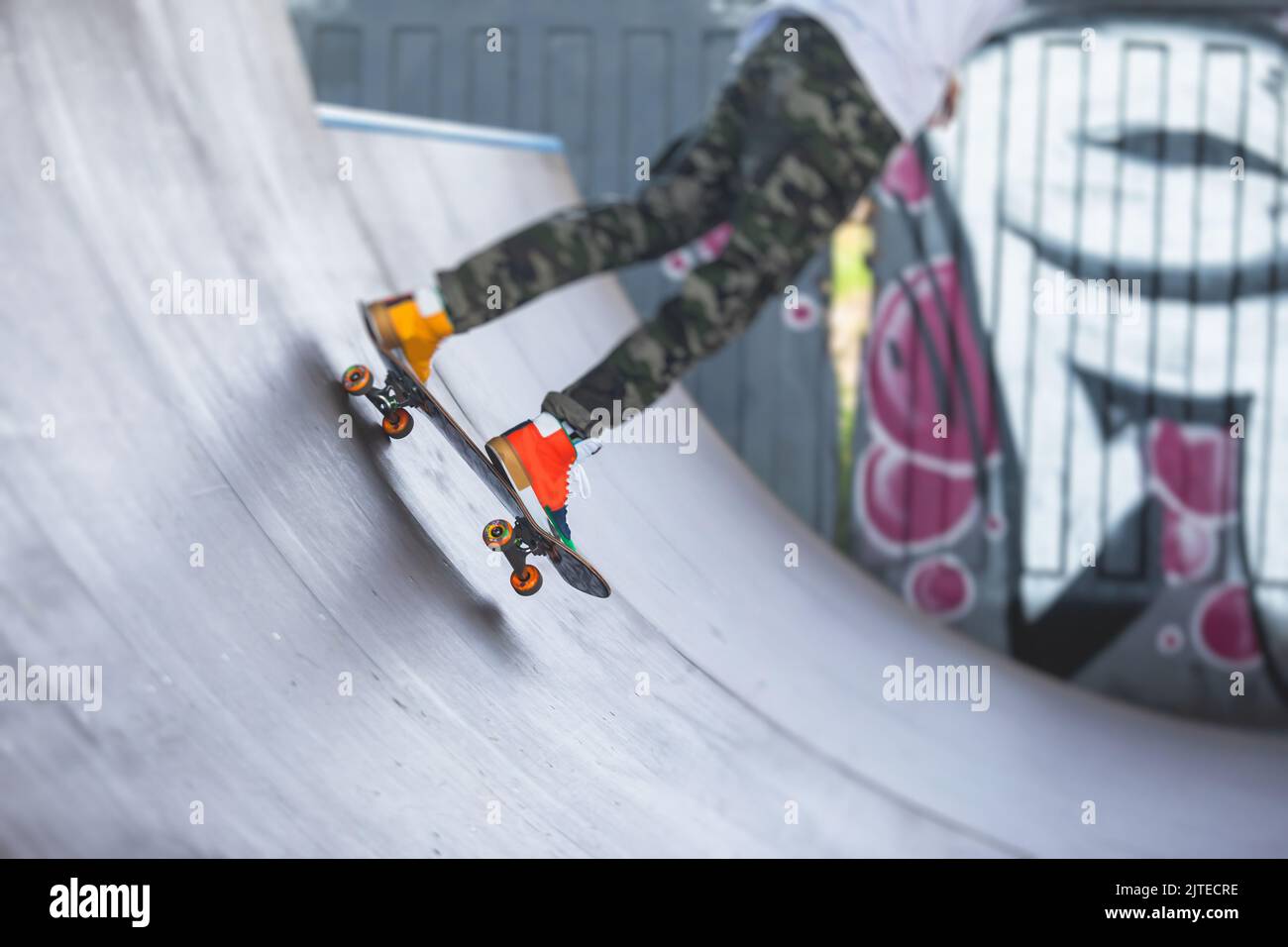 Skate park view with kids on a kick scooter doing tricks and stunts ...