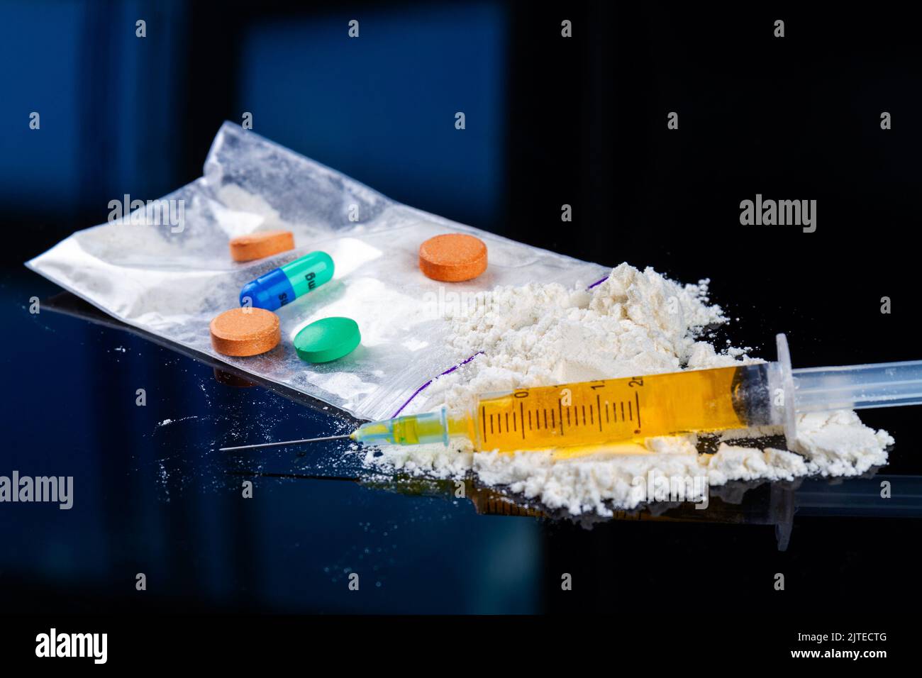 Close-up pile of powder and filled syringe with drugs. Drug addiction ...