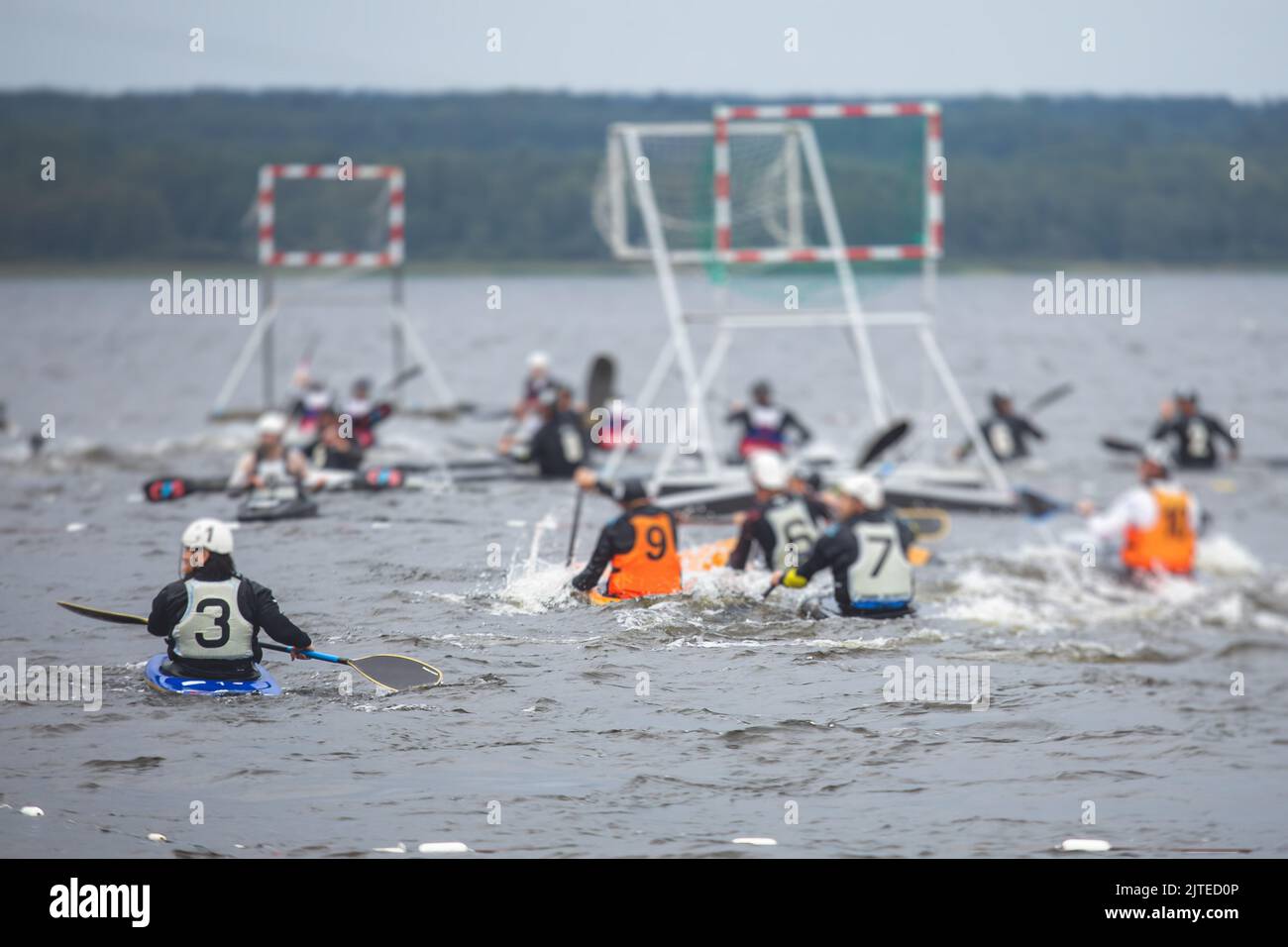 Canoe polo match, two teams play kayak polo game outdoor competition in ...