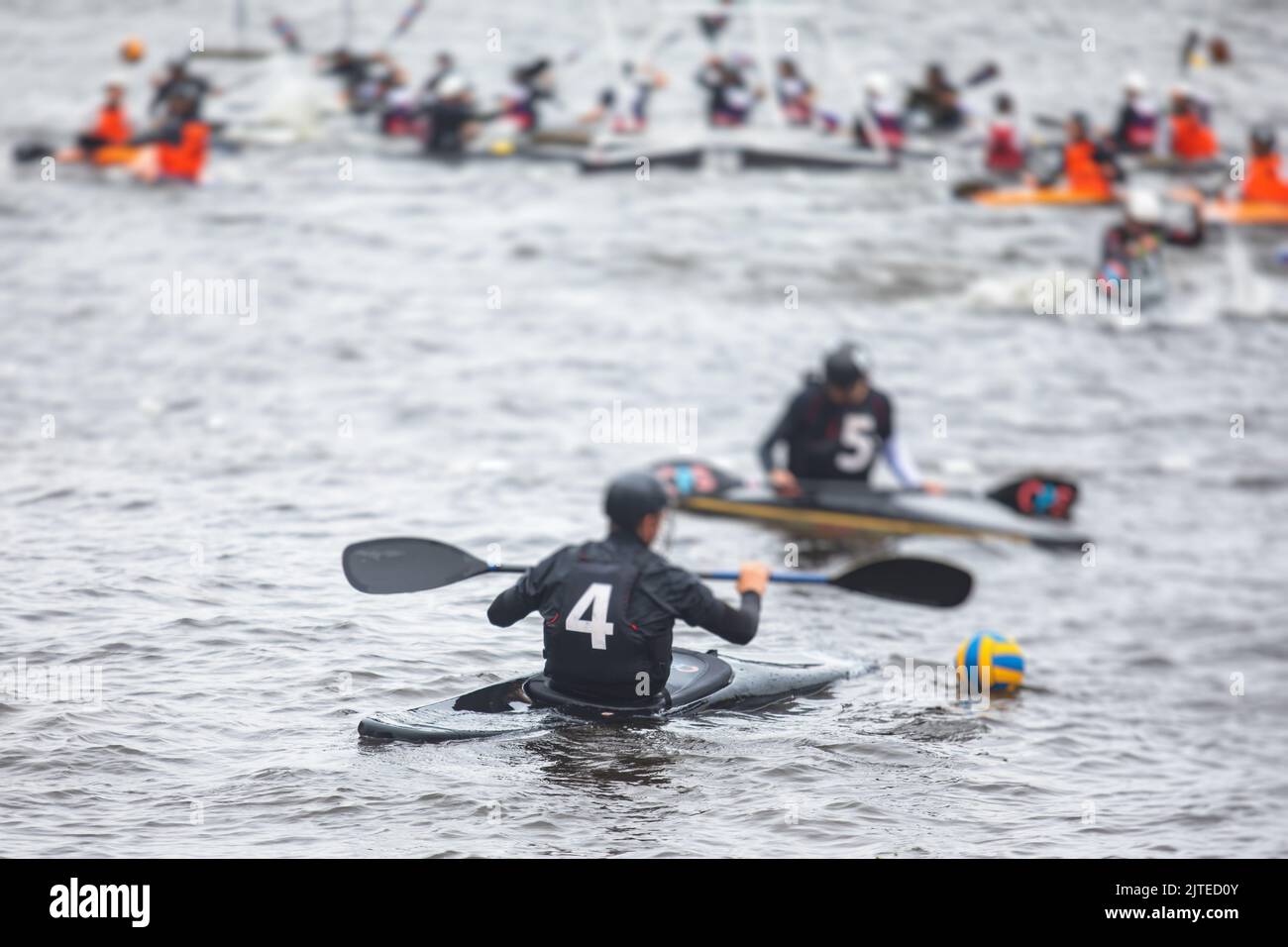 Canoe polo match, two teams play kayak polo game outdoor competition in ...