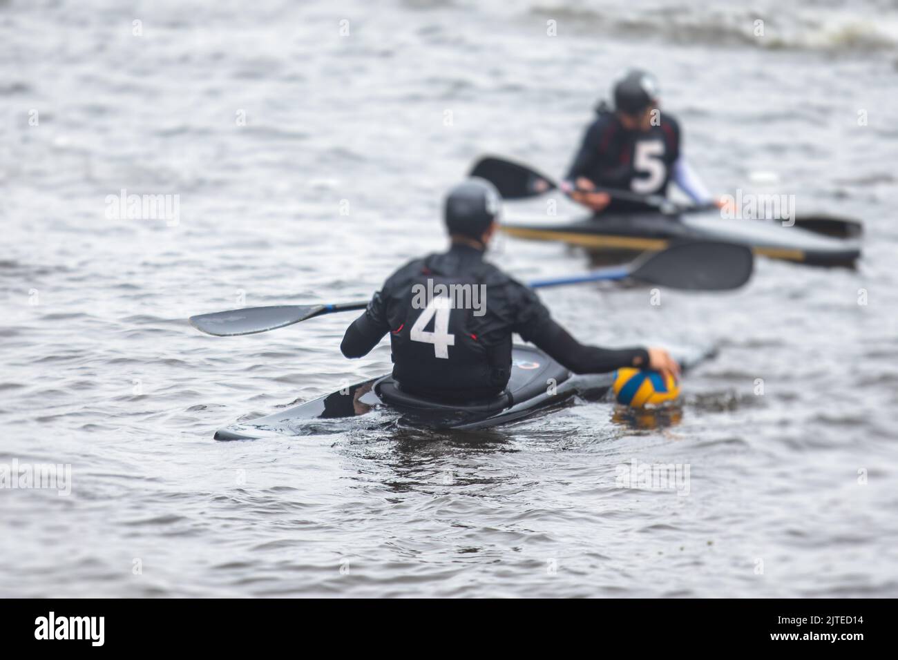 Canoe polo match, two teams play kayak polo game outdoor competition in ...