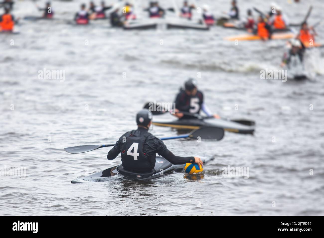 Canoe polo match, two teams play kayak polo game outdoor competition in ...