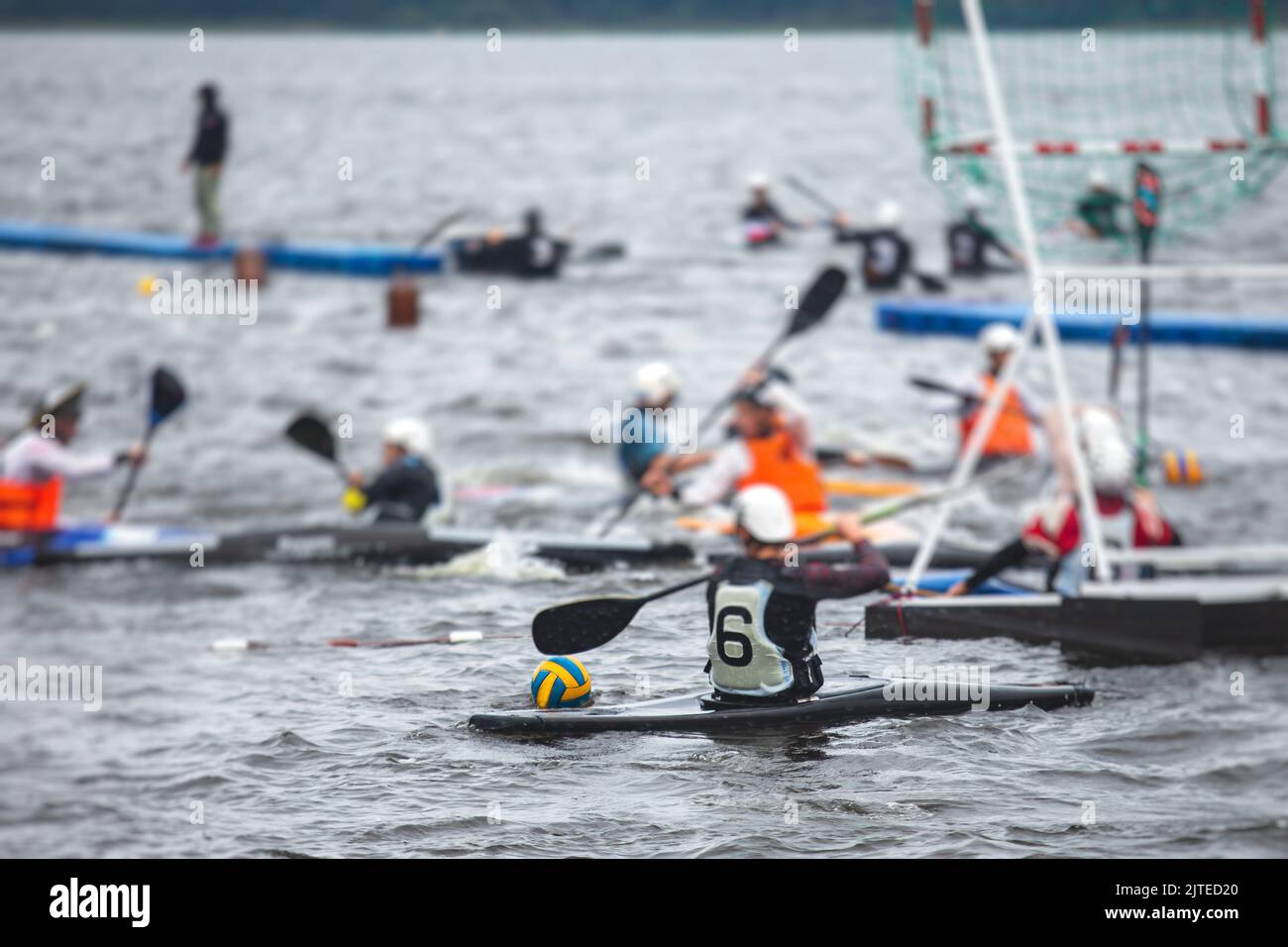 Canoe polo match, two teams play kayak polo game outdoor competition in ...