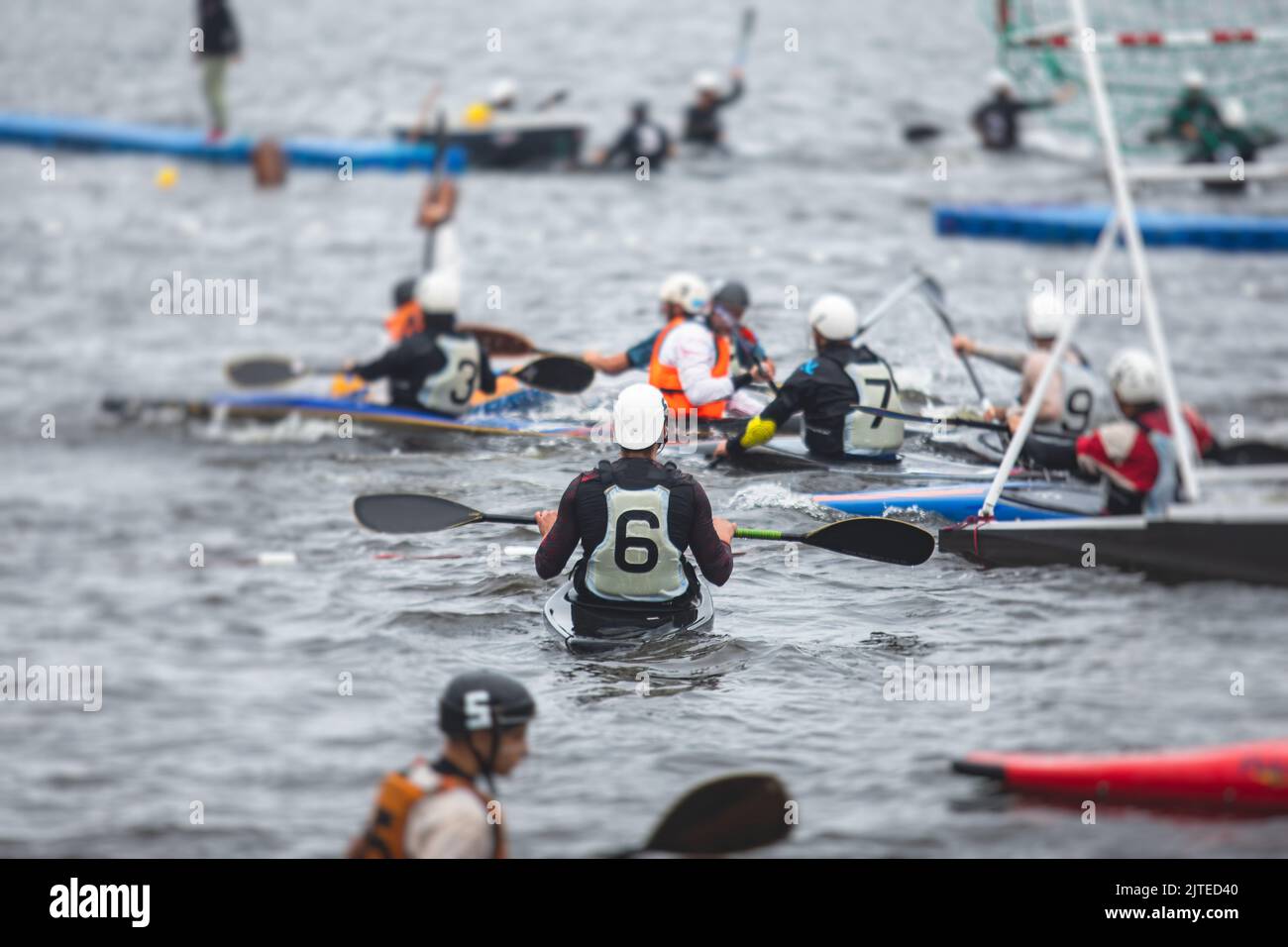 Canoe polo match, two teams play kayak polo game outdoor competition in ...