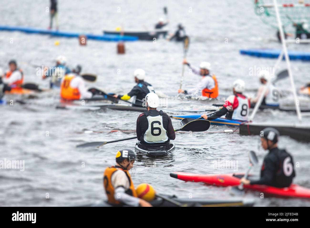 Canoe polo match, two teams play kayak polo game outdoor competition in ...