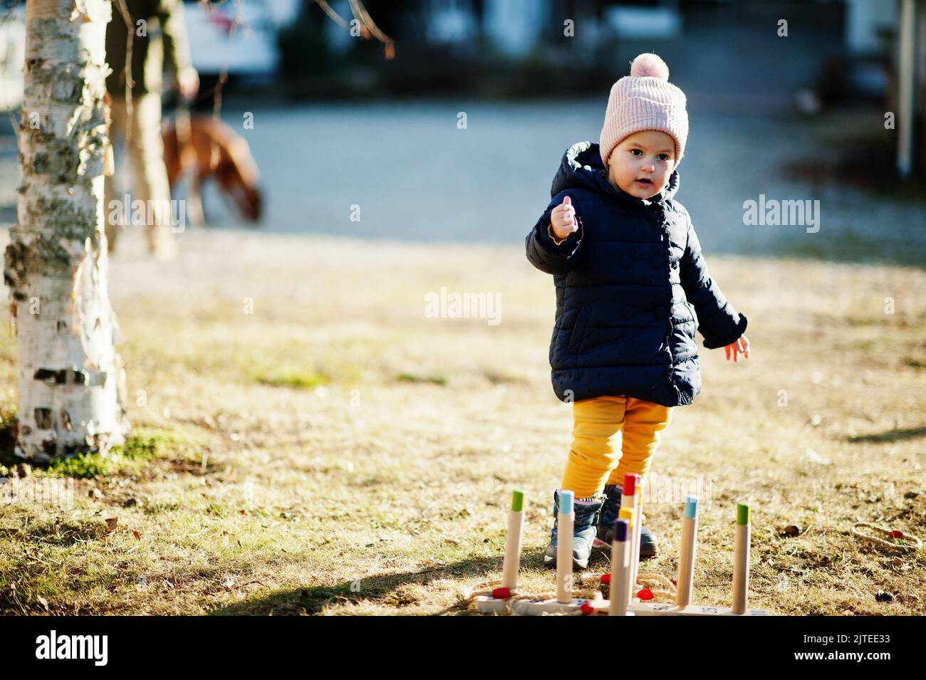 Baby girl playing a game throwing ring toss outdoor Stock Photo - Alamy