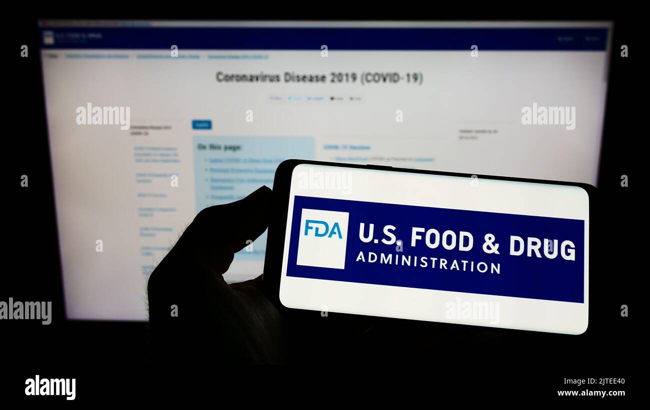 Person holding cellphone with logo of United States Food and Drug ...