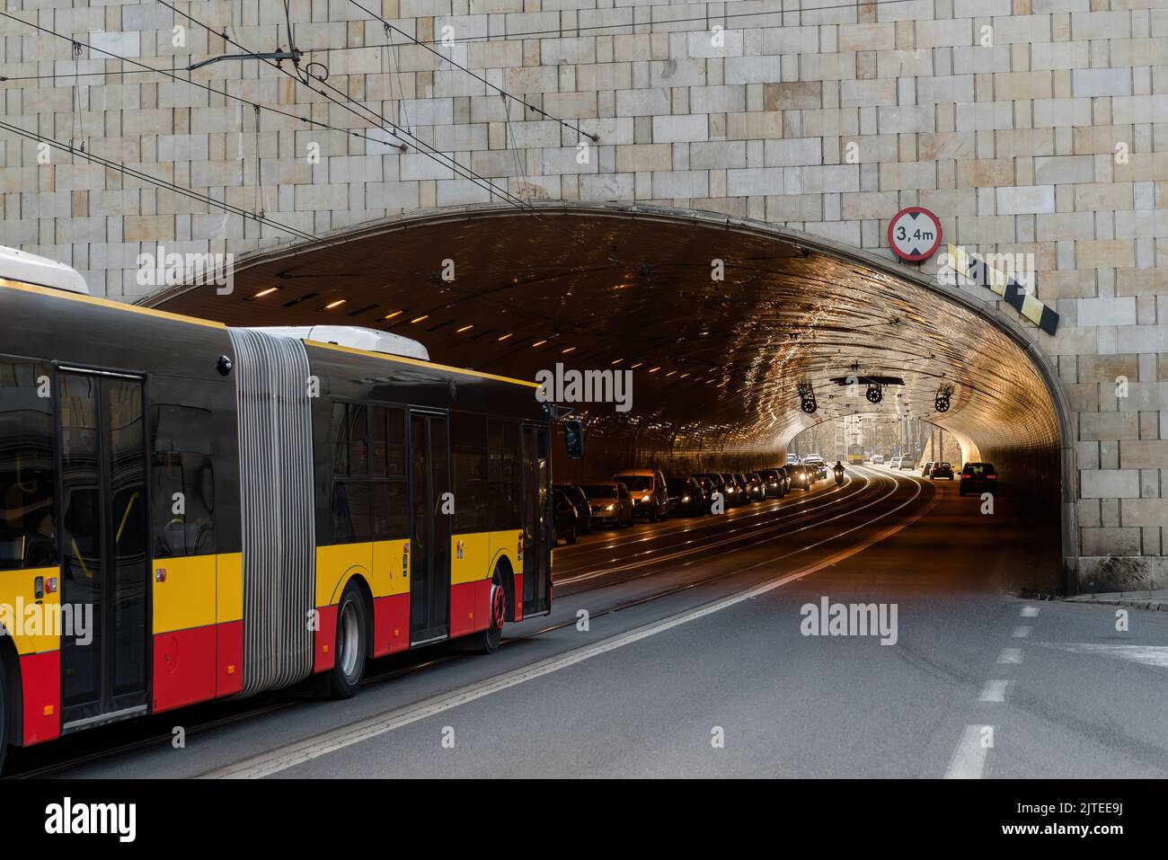 The city long bus drives into the tunnel under the bridge Stock Photo ...