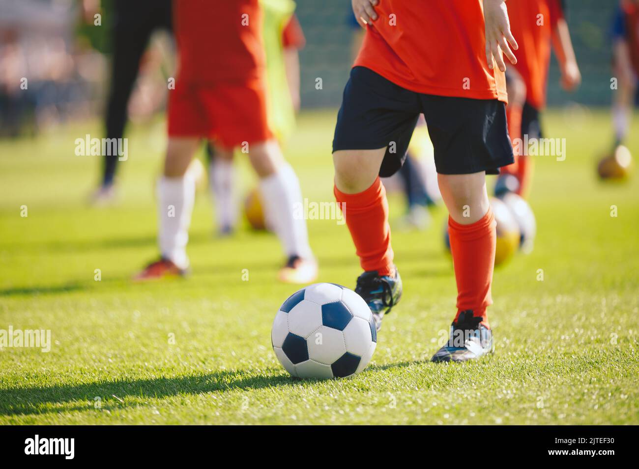 Boys attending soccer training on school field. Young man coaching ...