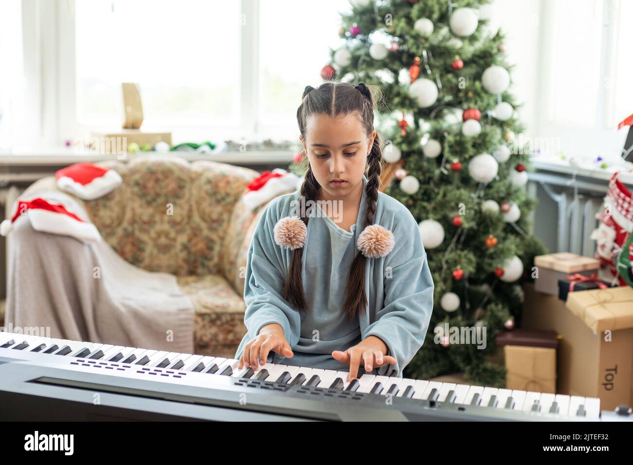 Christmas child little girl playing on piano at home Stock Photo - Alamy