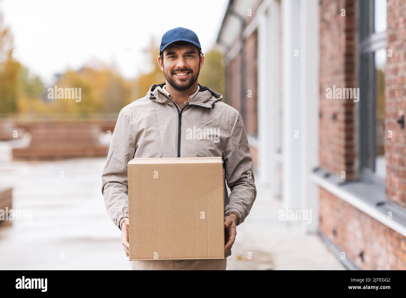 smiling delivery man with parcel box Stock Photo - Alamy