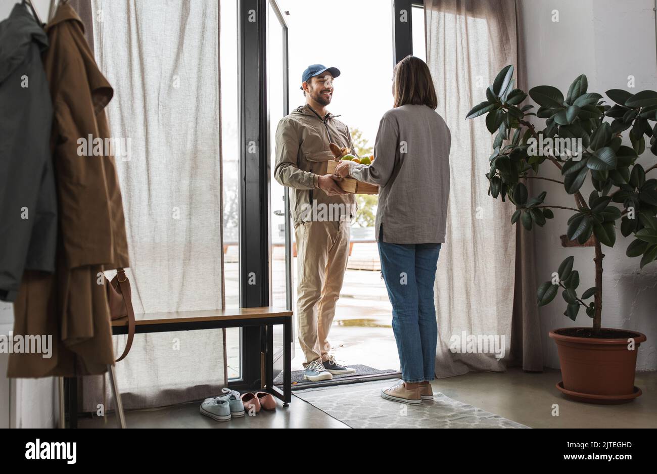 food delivery man giving order to female customer Stock Photo - Alamy