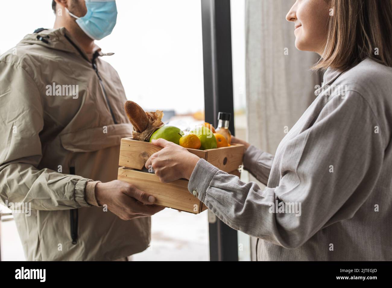 food delivery man in mask giving order to customer Stock Photo - Alamy