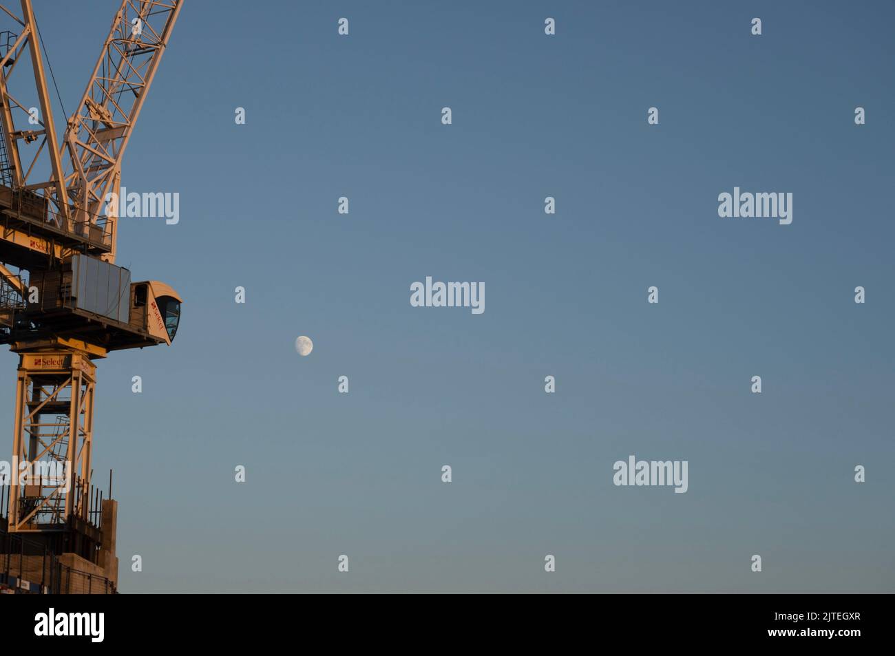 The late evening moon against the blue sky in the background of a metal ...