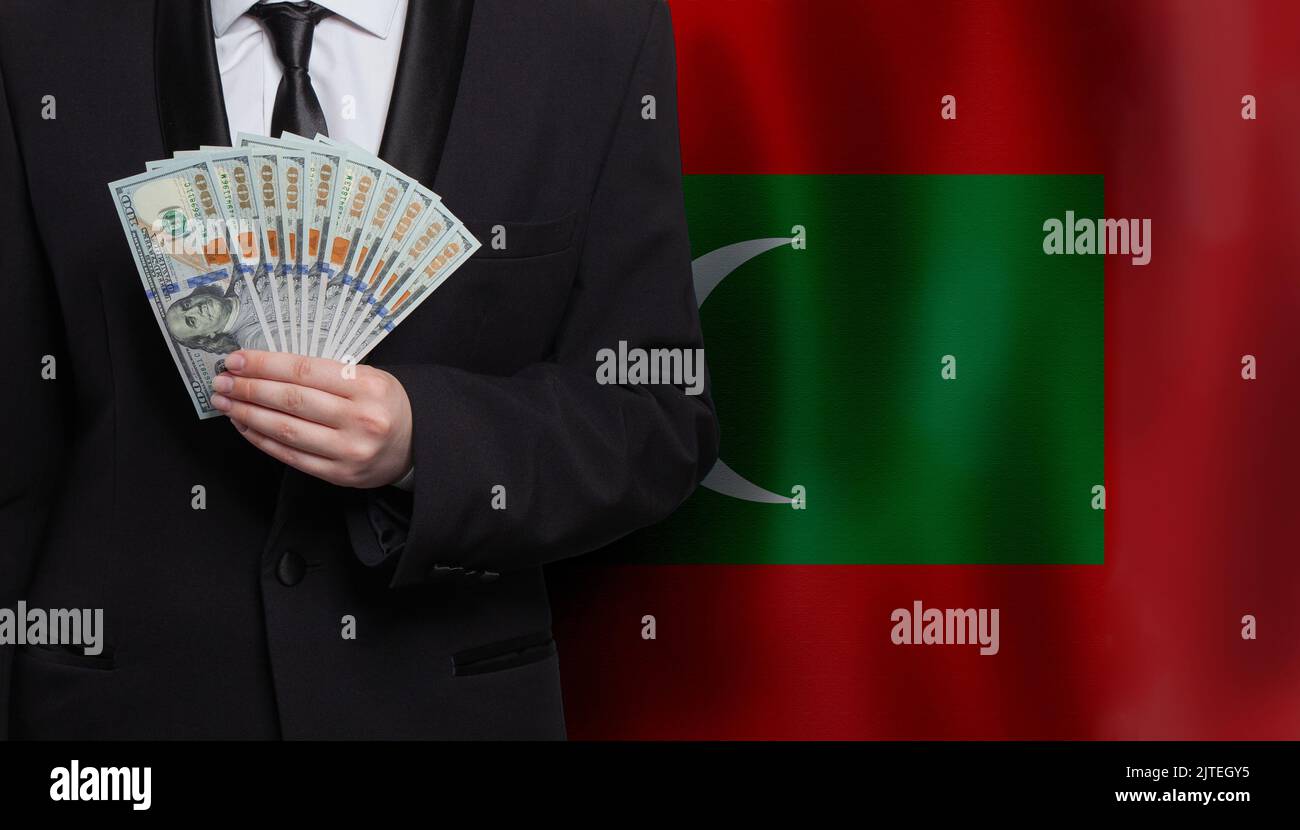 US dollar bills money banknotes in hand against flag of Maldives ...