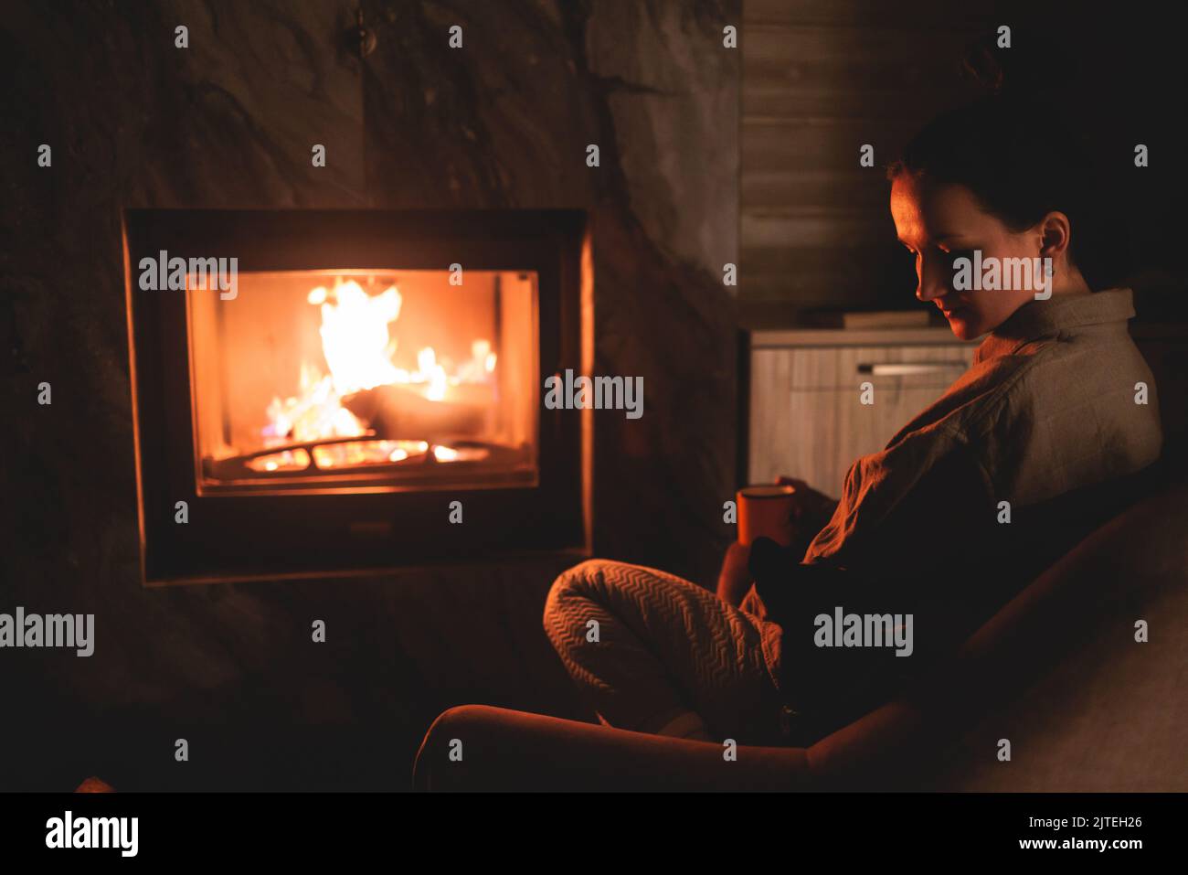 Cozy night in the cabin by the fireplace, fireplace burns in the ...