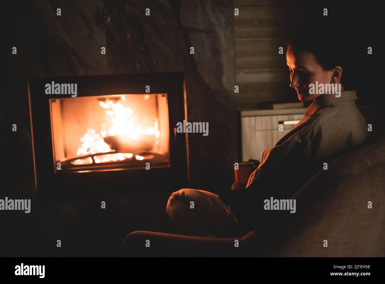 Cozy night in the cabin by the fireplace, fireplace burns in the ...