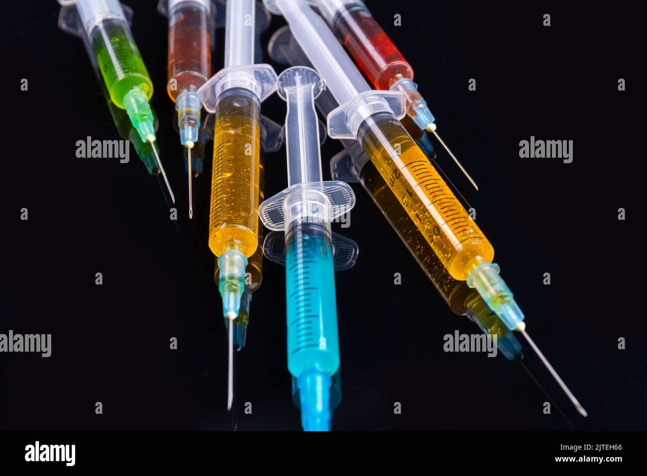Close-up syringes with colored medicine isolated on black background ...