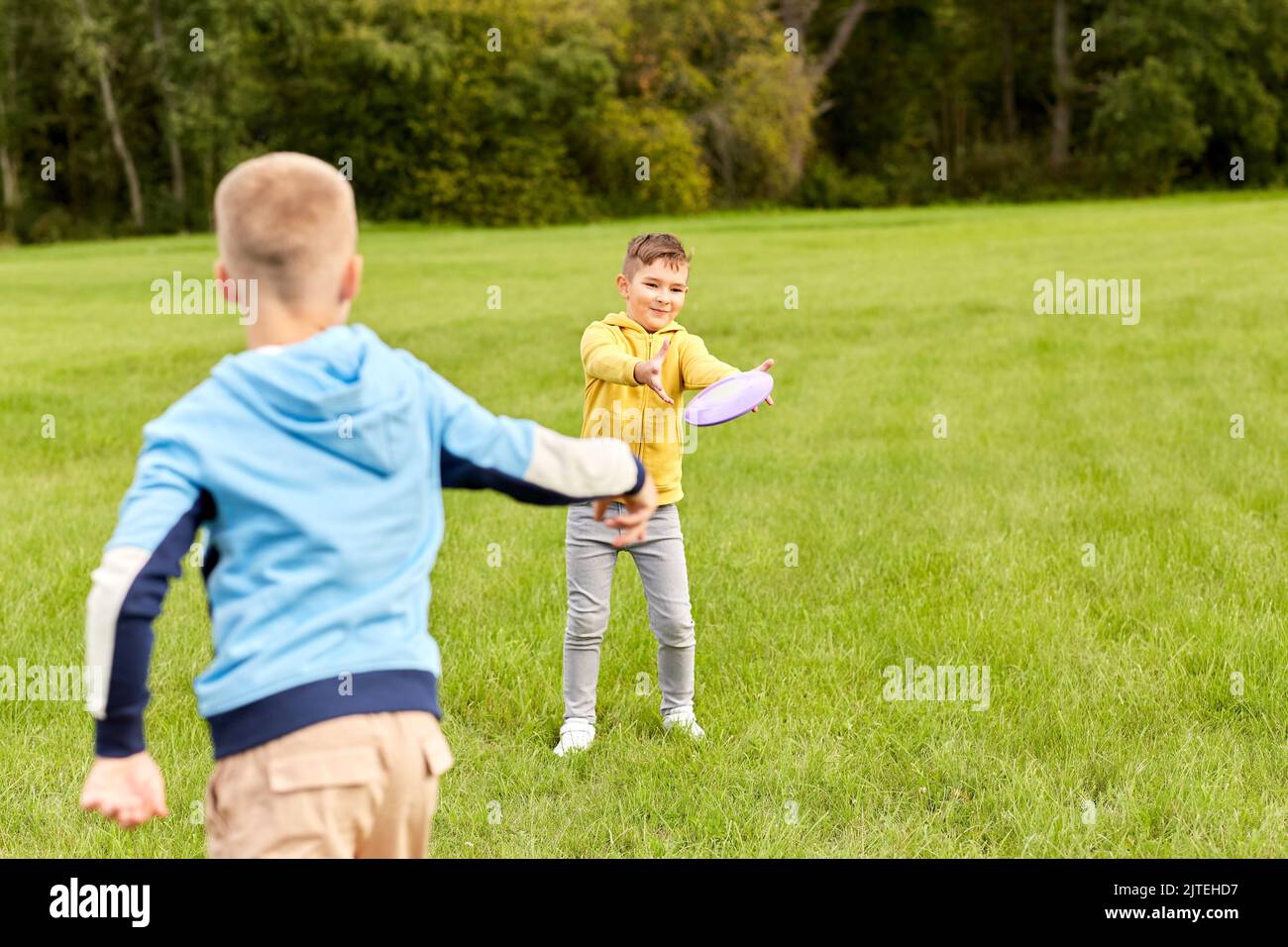 happy boys playing with flying disc at park Stock Photo - Alamy