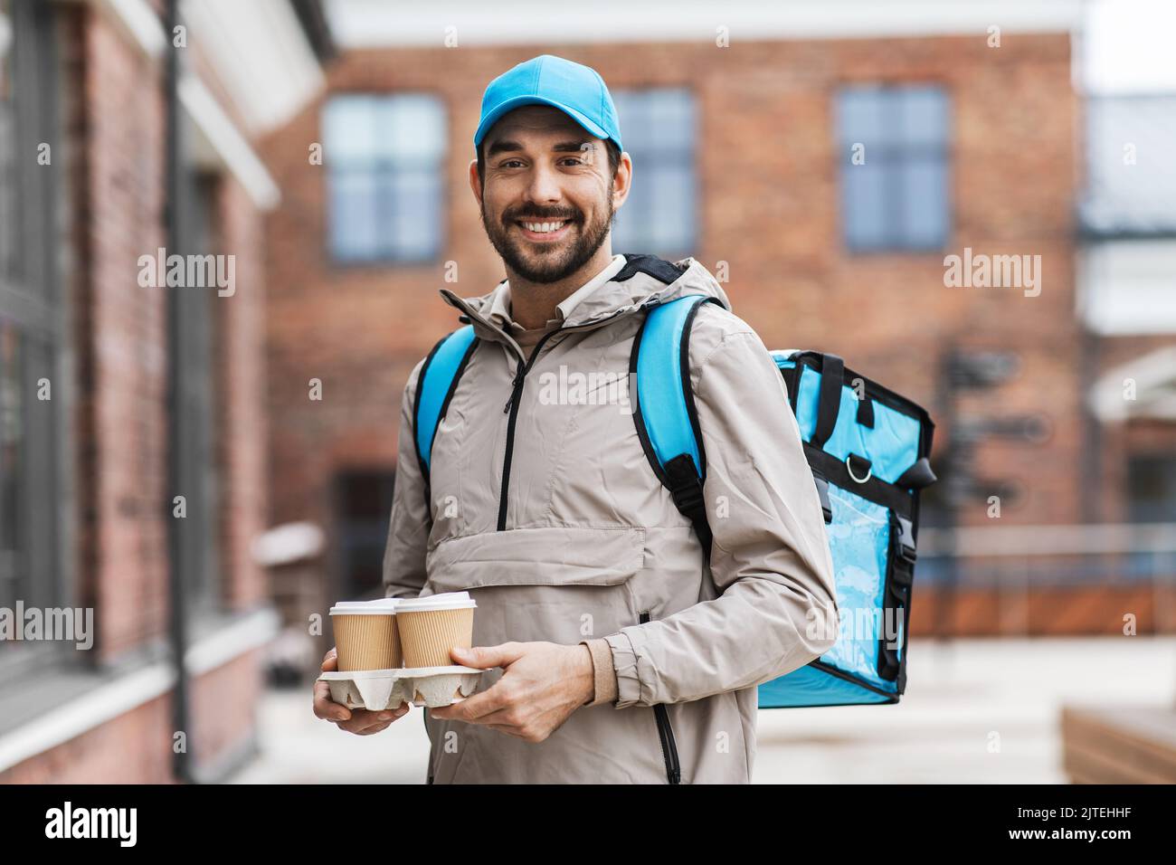 happy delivery man with thermal bag and coffee Stock Photo - Alamy