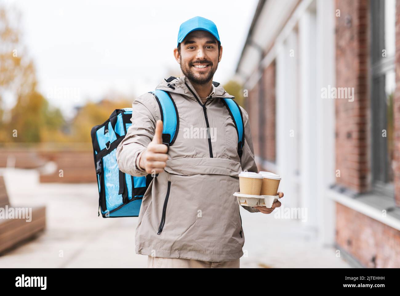 happy delivery man with thermal bag and coffee Stock Photo - Alamy