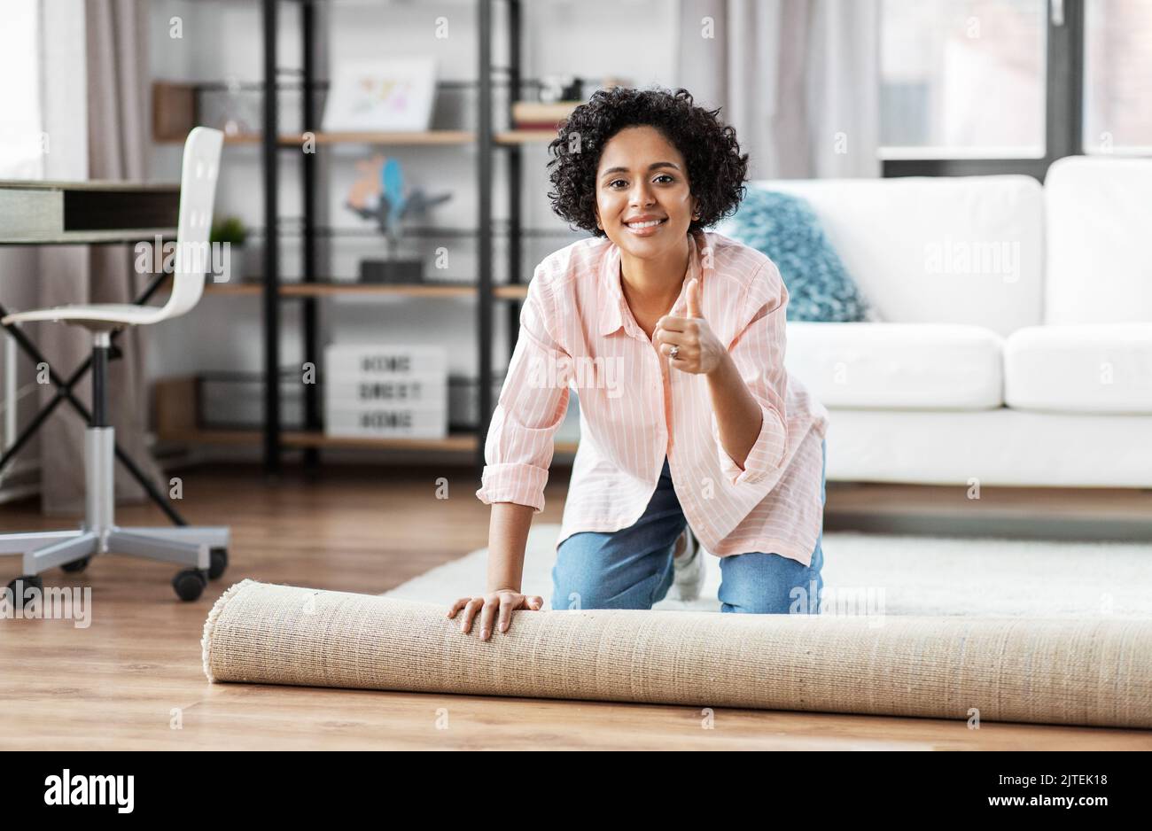 happy woman with carpet showing thumbs up at home Stock Photo - Alamy