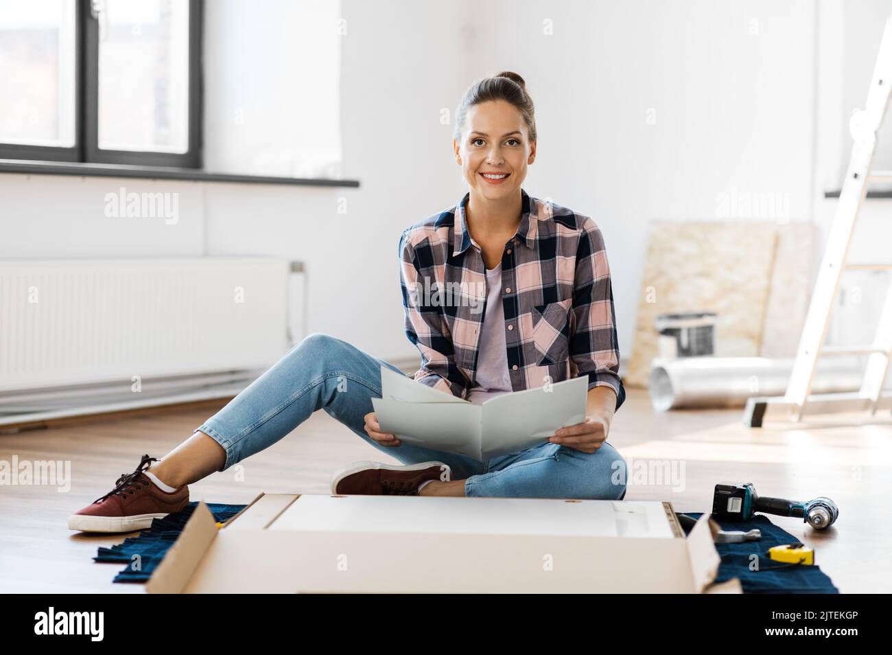 happy smiling woman assembling furniture at home Stock Photo - Alamy