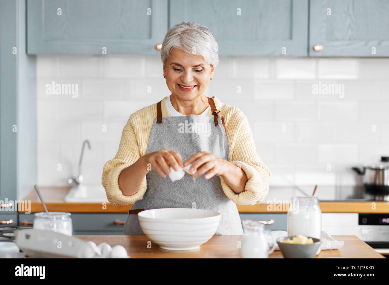 Woman breaking egg bowl hi-res stock photography and images - Alamy