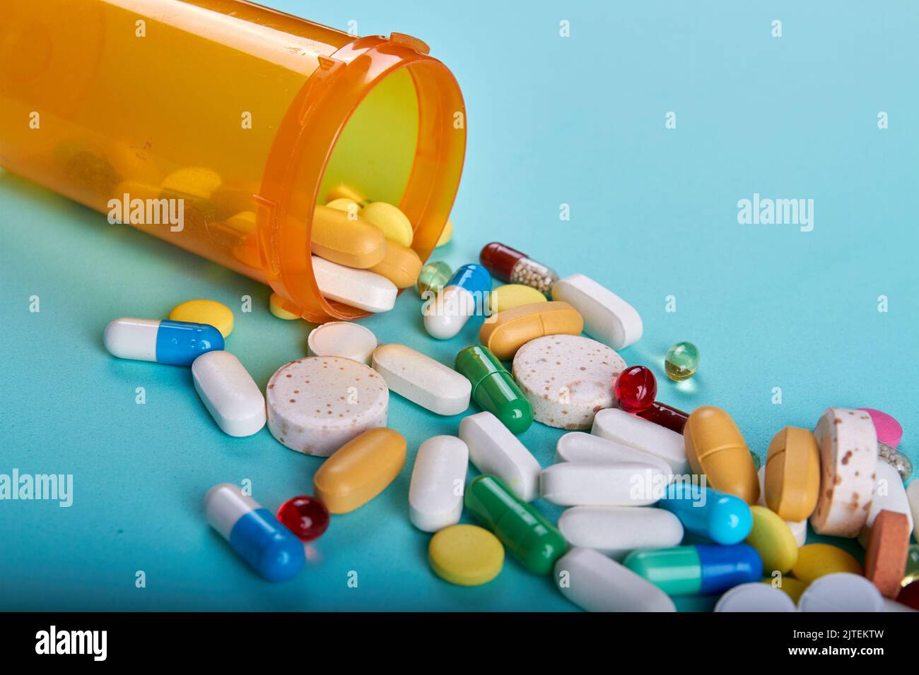 Many various pills capsules and tablets from orange plastic bottle ...