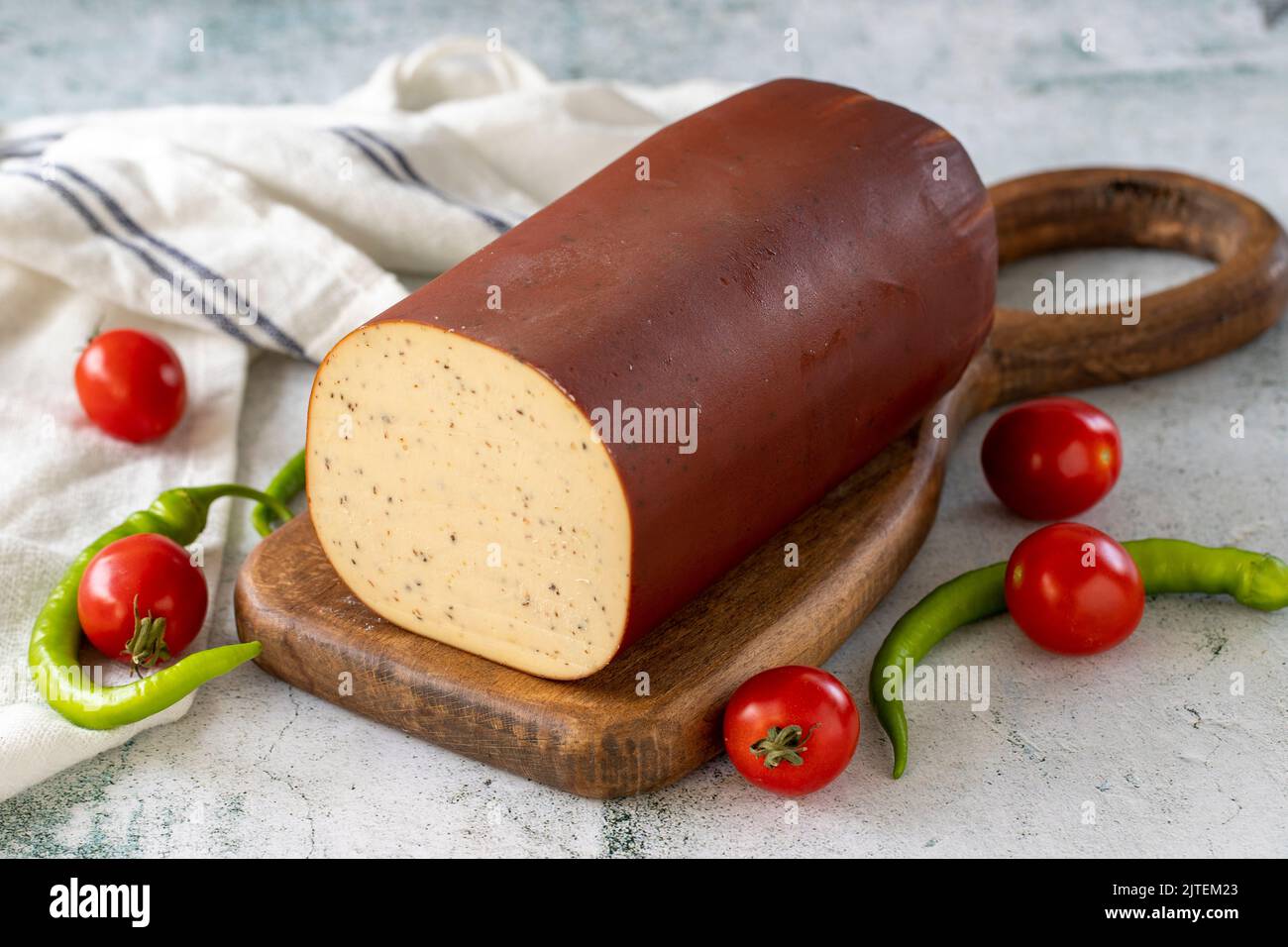 Black Pepper Smoked Cheese. Dutch smoked cheese on stone background ...