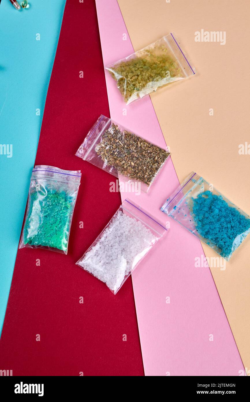Vertical shot packets of various colored stuff top view. Crystal drugs ...
