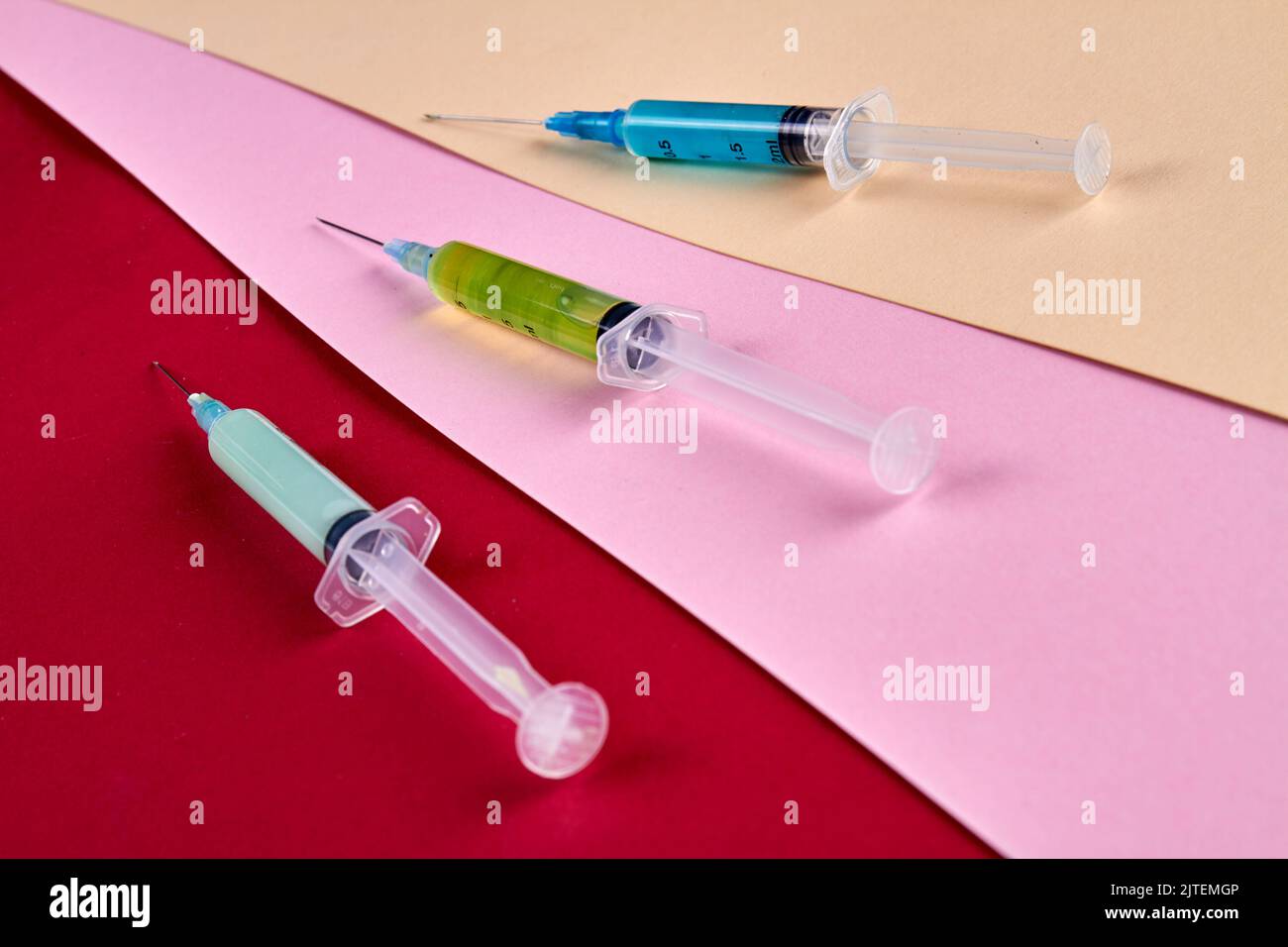 Close-up three syringes filled with multicolored medicine liquids ...